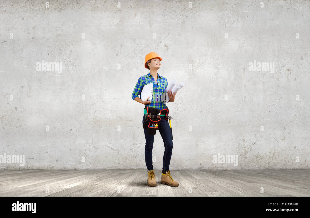 Attractive smiling woman engineer wearing helmet and tool belt Stock ...