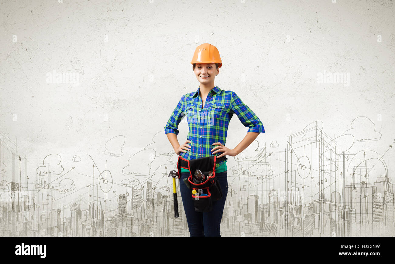 Attractive smiling woman engineer wearing helmet and tool belt Stock ...