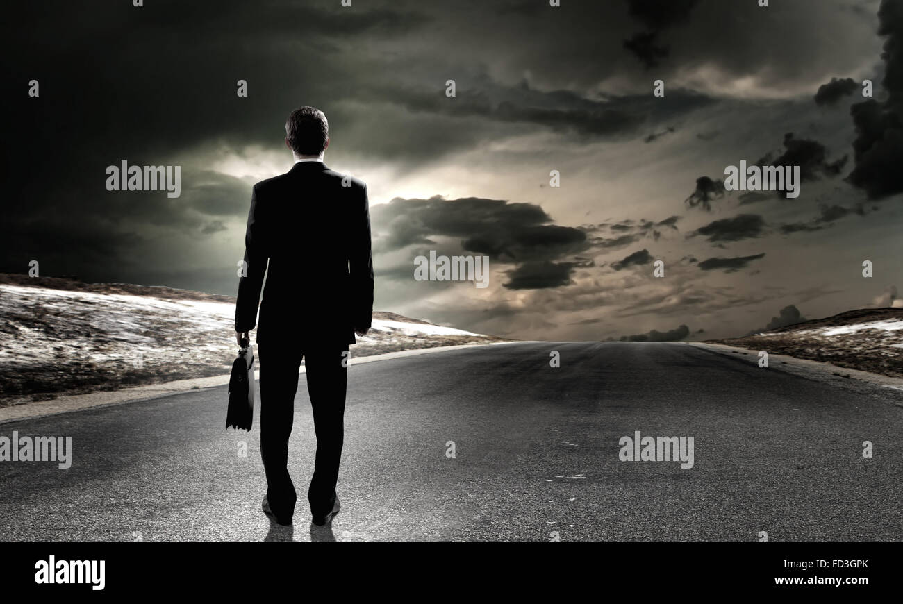 Back view of businessman standing on road and looking far away Stock ...