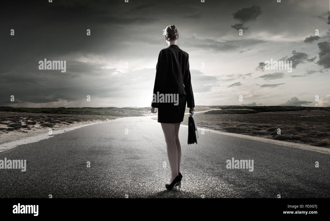 Back view of businesswoman standing on road and looking far away Stock ...