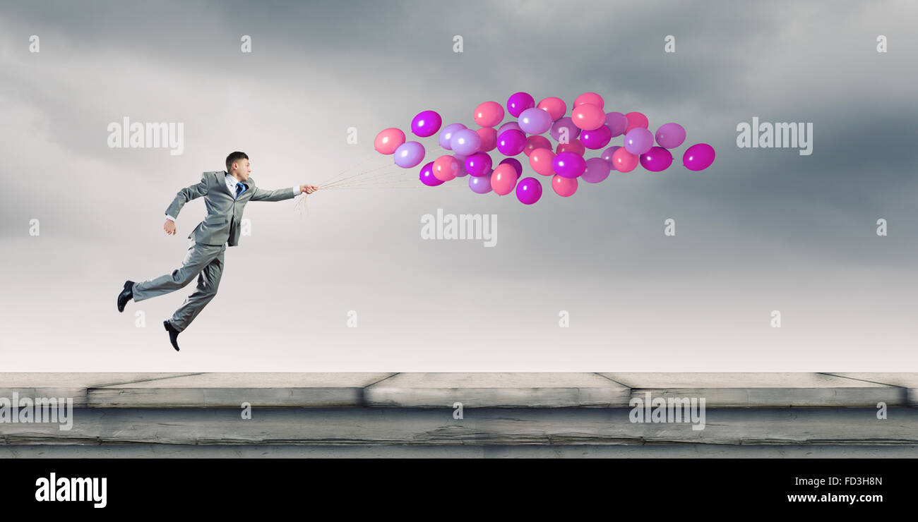 Cheerful businessman running with bunch of colorful balloons Stock ...