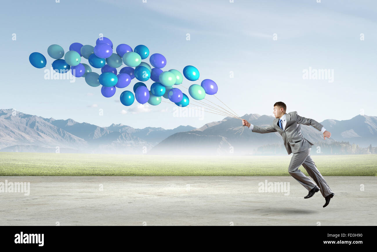 Cheerful businessman running with bunch of colorful balloons Stock ...