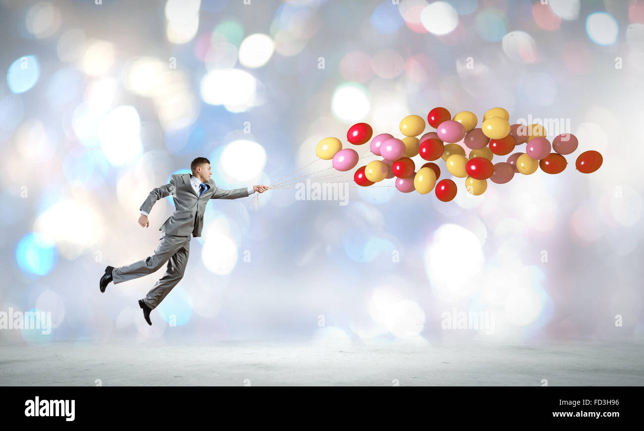 Cheerful businessman running with bunch of colorful balloons Stock ...