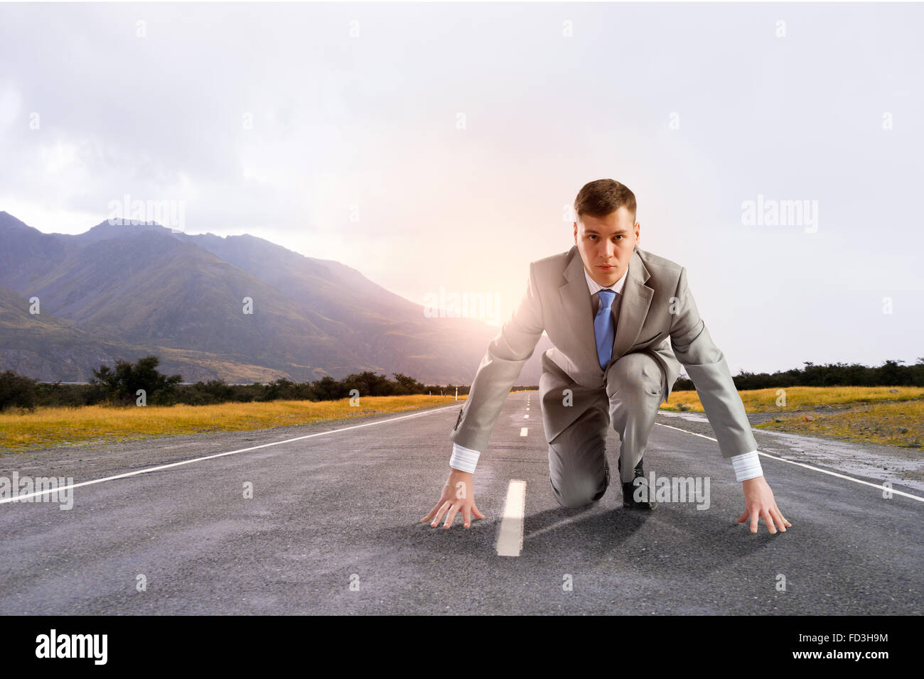 Young determined businessman standing in start position Stock Photo - Alamy