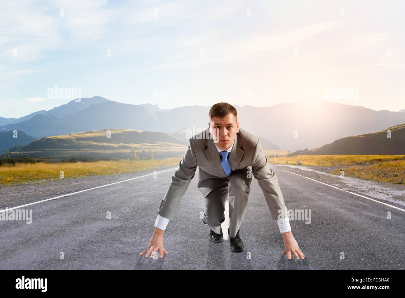 Young determined businessman standing in start position Stock Photo - Alamy