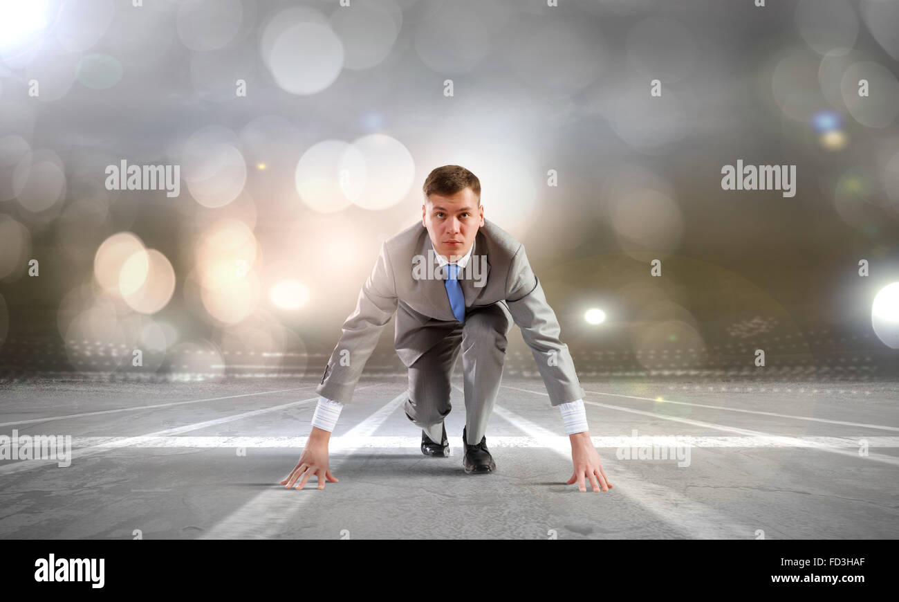 Young determined businessman standing in start position Stock Photo - Alamy