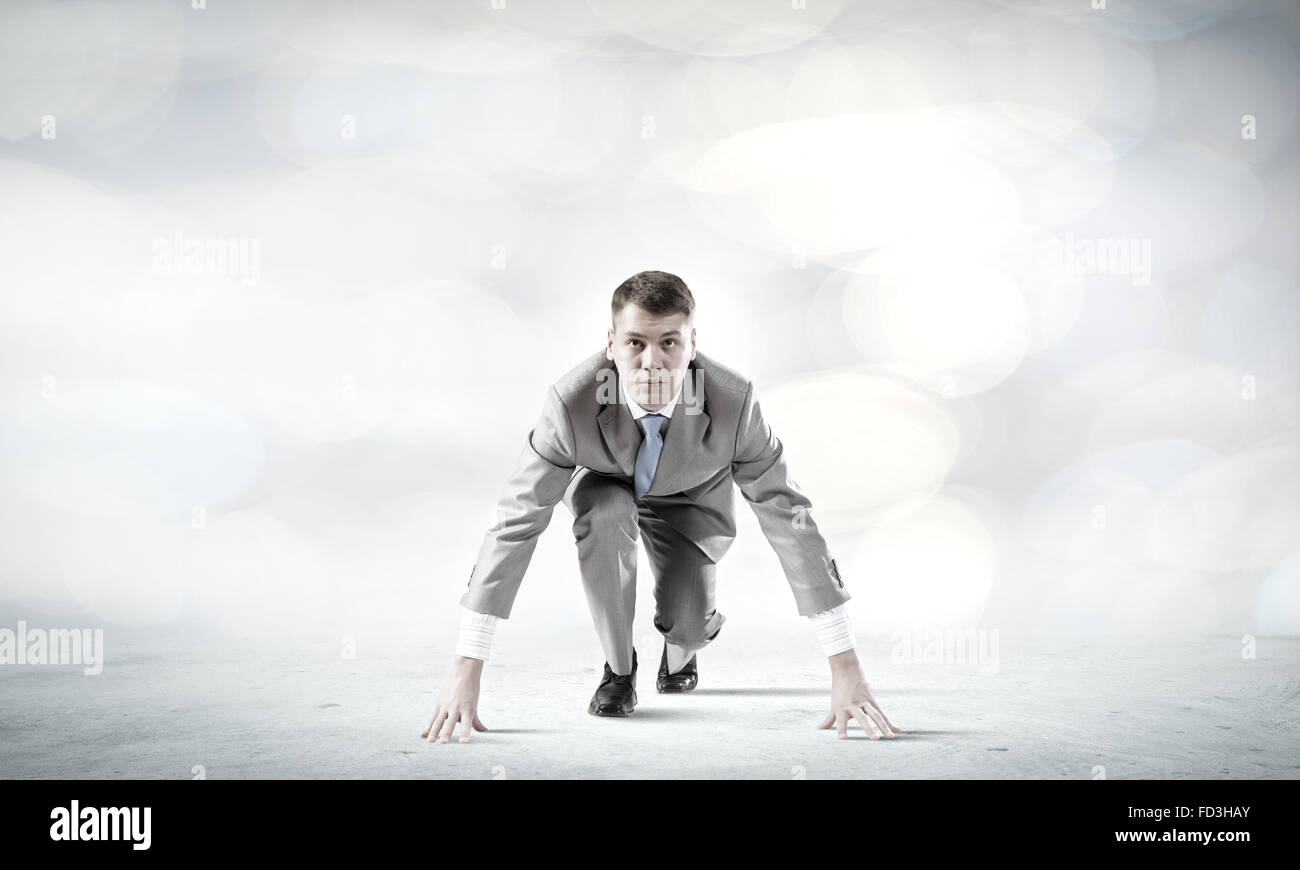 Young determined businessman standing in start position Stock Photo - Alamy