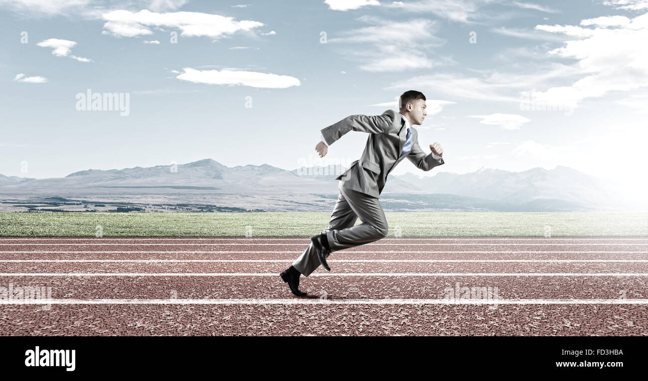 Young businessman in suit running on track Stock Photo - Alamy