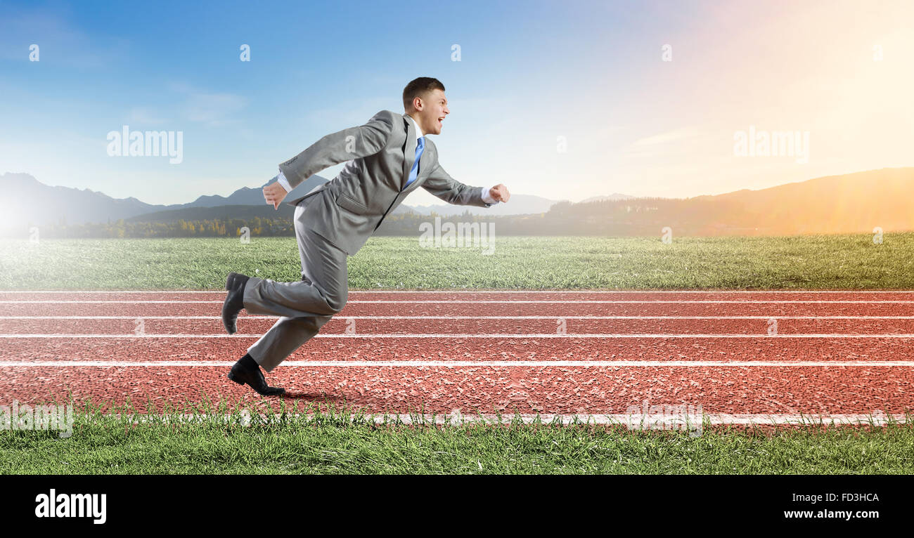 Young businessman in suit running on track Stock Photo - Alamy