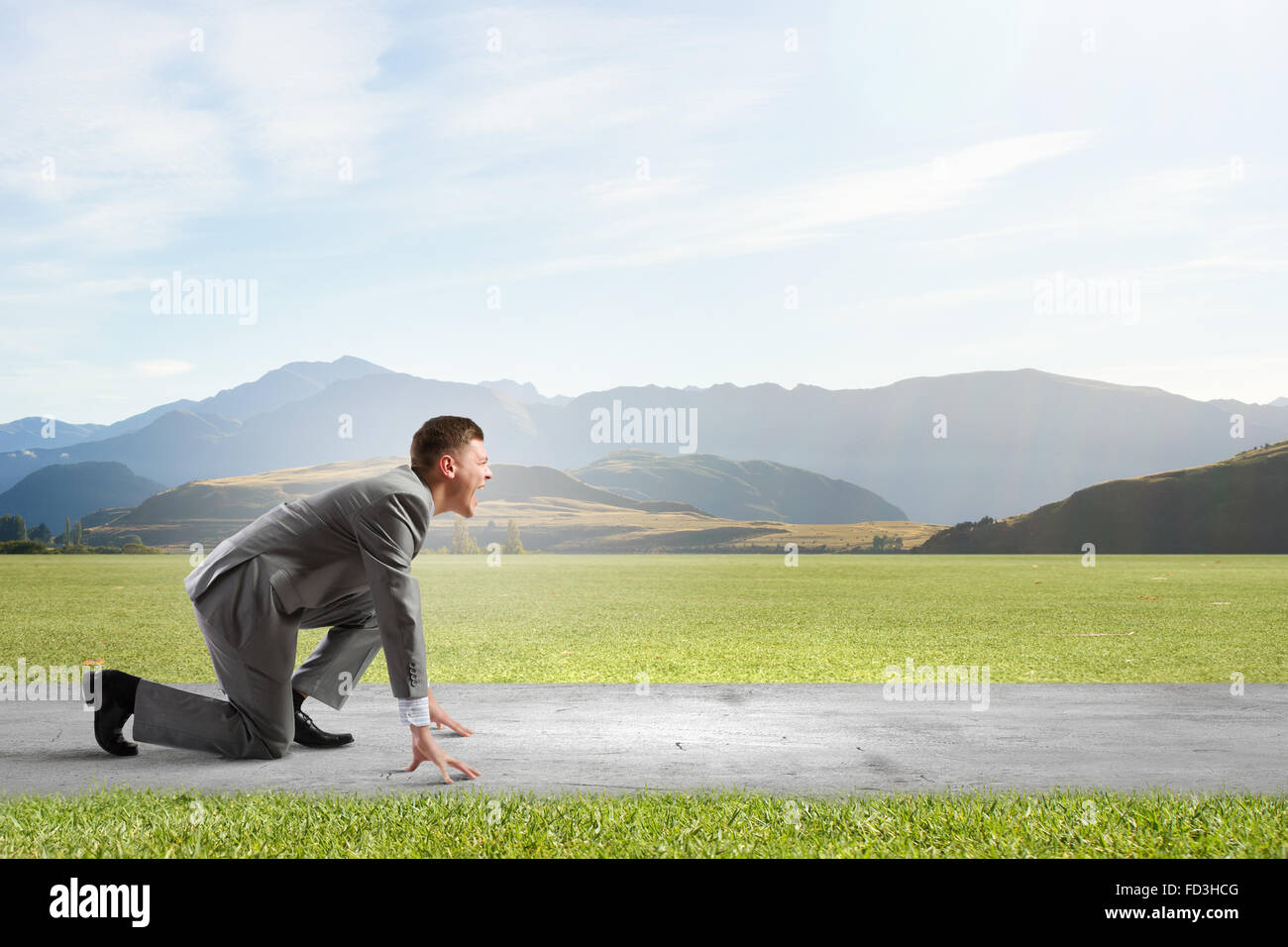 Side view of young businessman in start position ready to run Stock ...