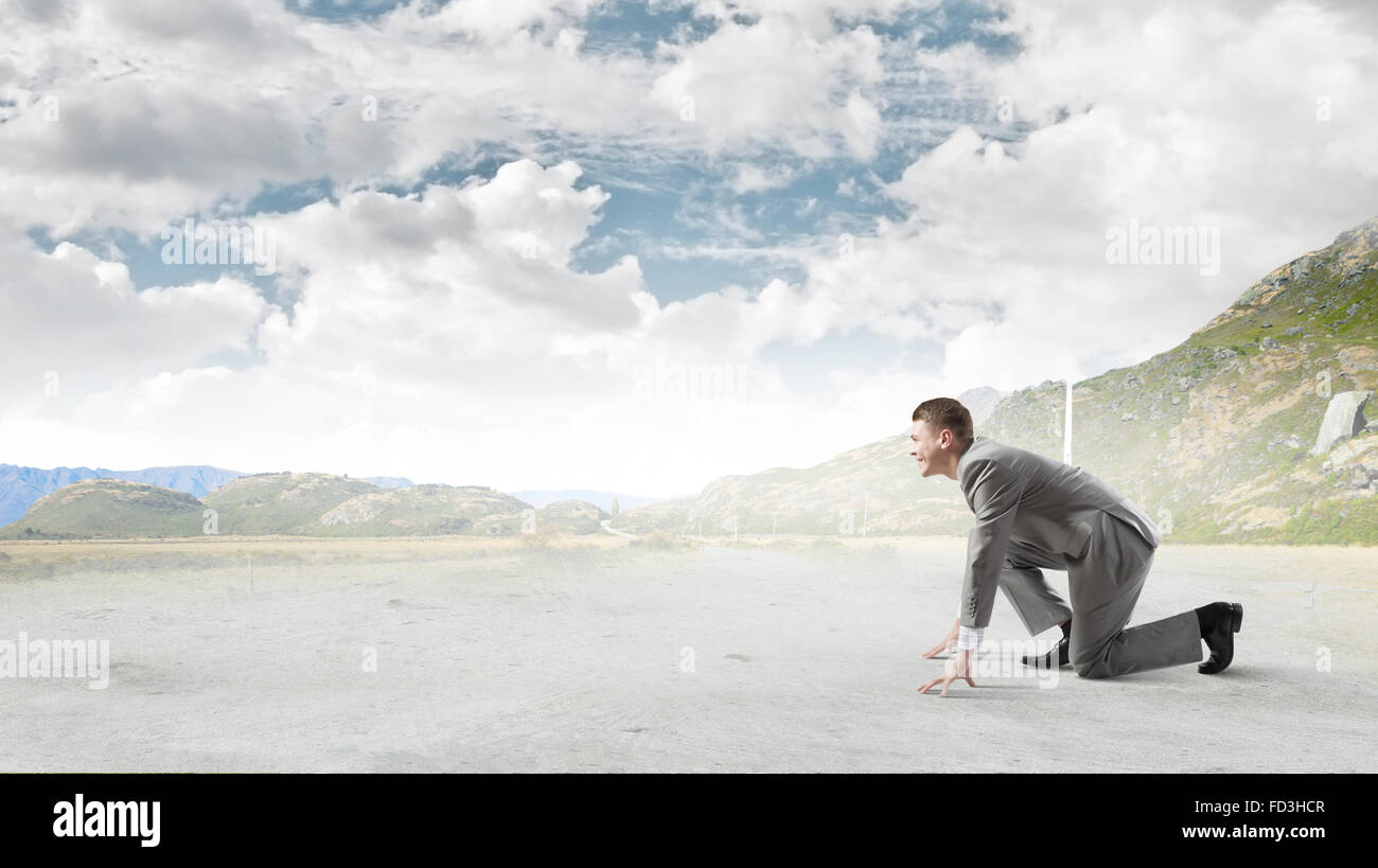 Side view of young businessman in start position ready to run Stock ...