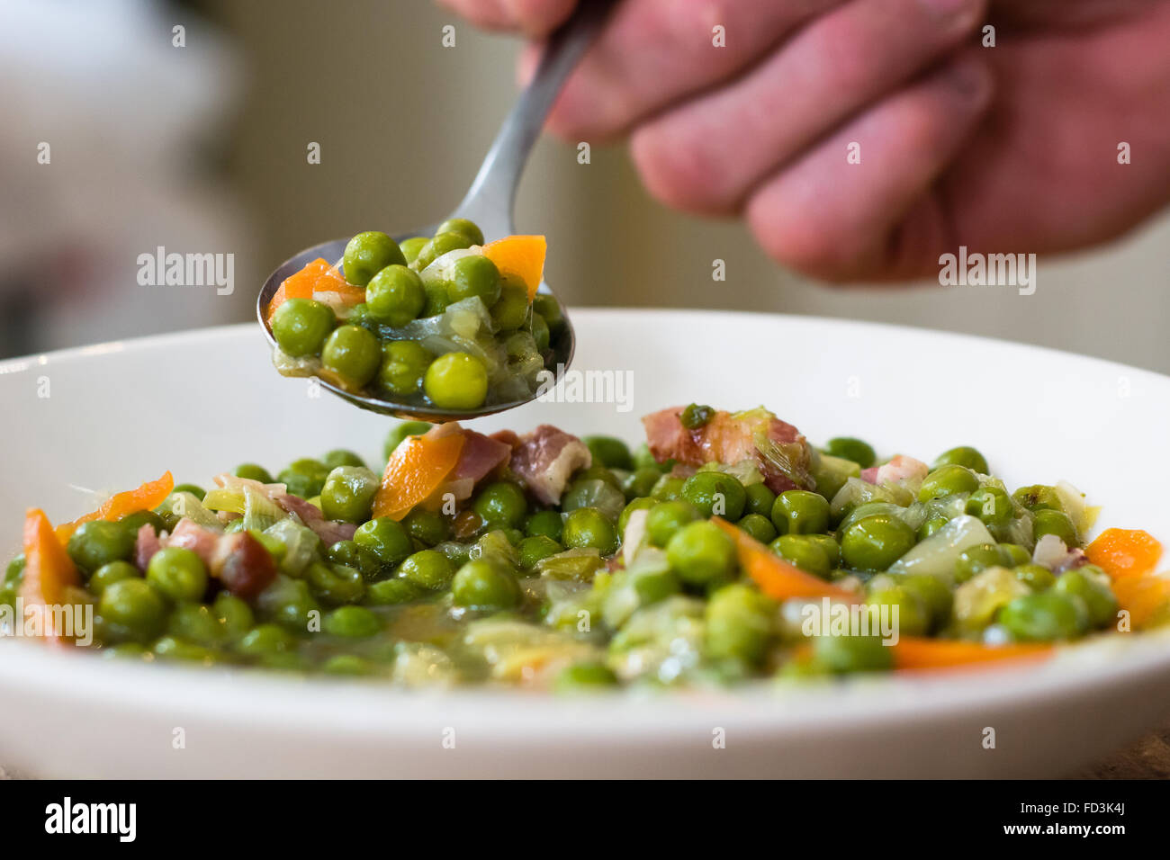 Petit pois a la Francaise with spoon. A traditional popular French dish ...