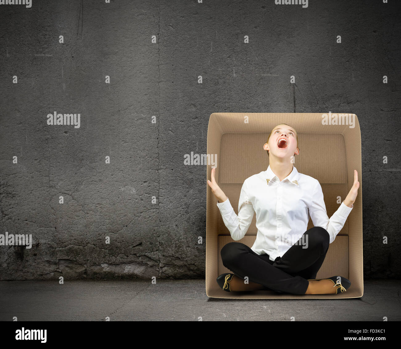 Young businesswoman sitting in carton box and feeling uncomfortable ...