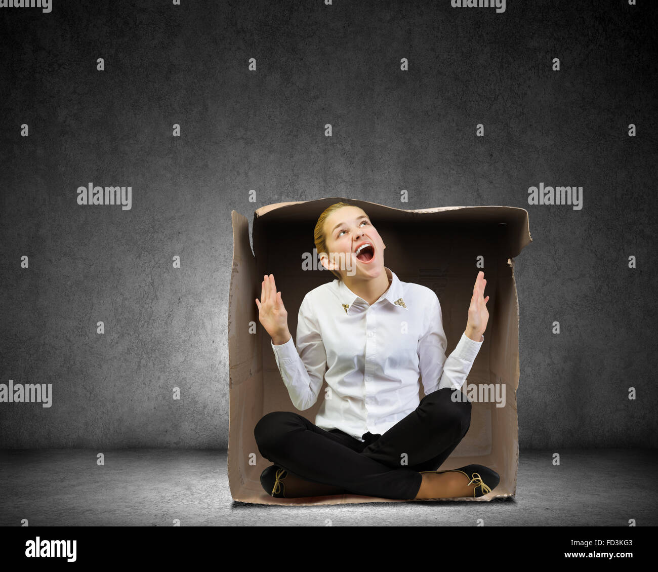 Young businesswoman sitting in carton box and feeling uncomfortable ...