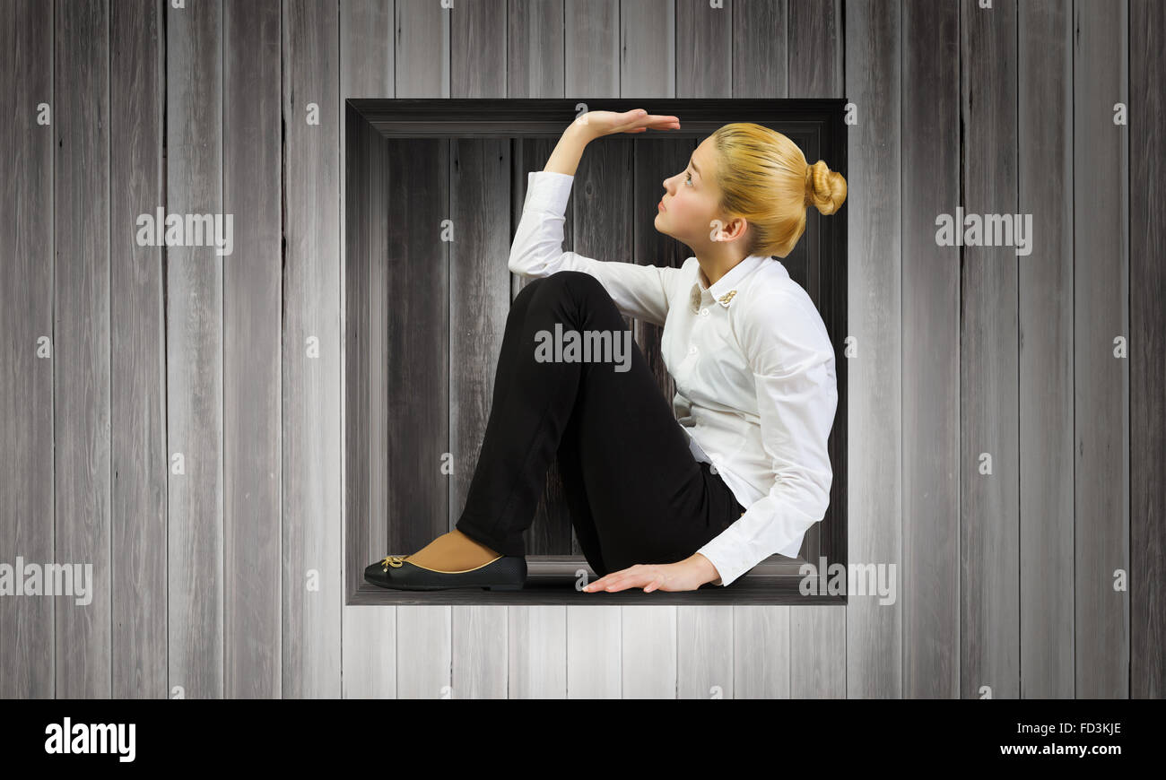 Young woman trapped in wooden cube in wall Stock Photo - Alamy