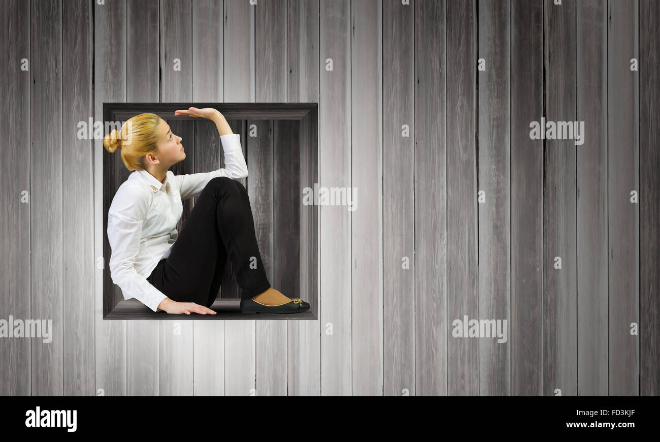 Young woman trapped in wooden cube in wall Stock Photo - Alamy