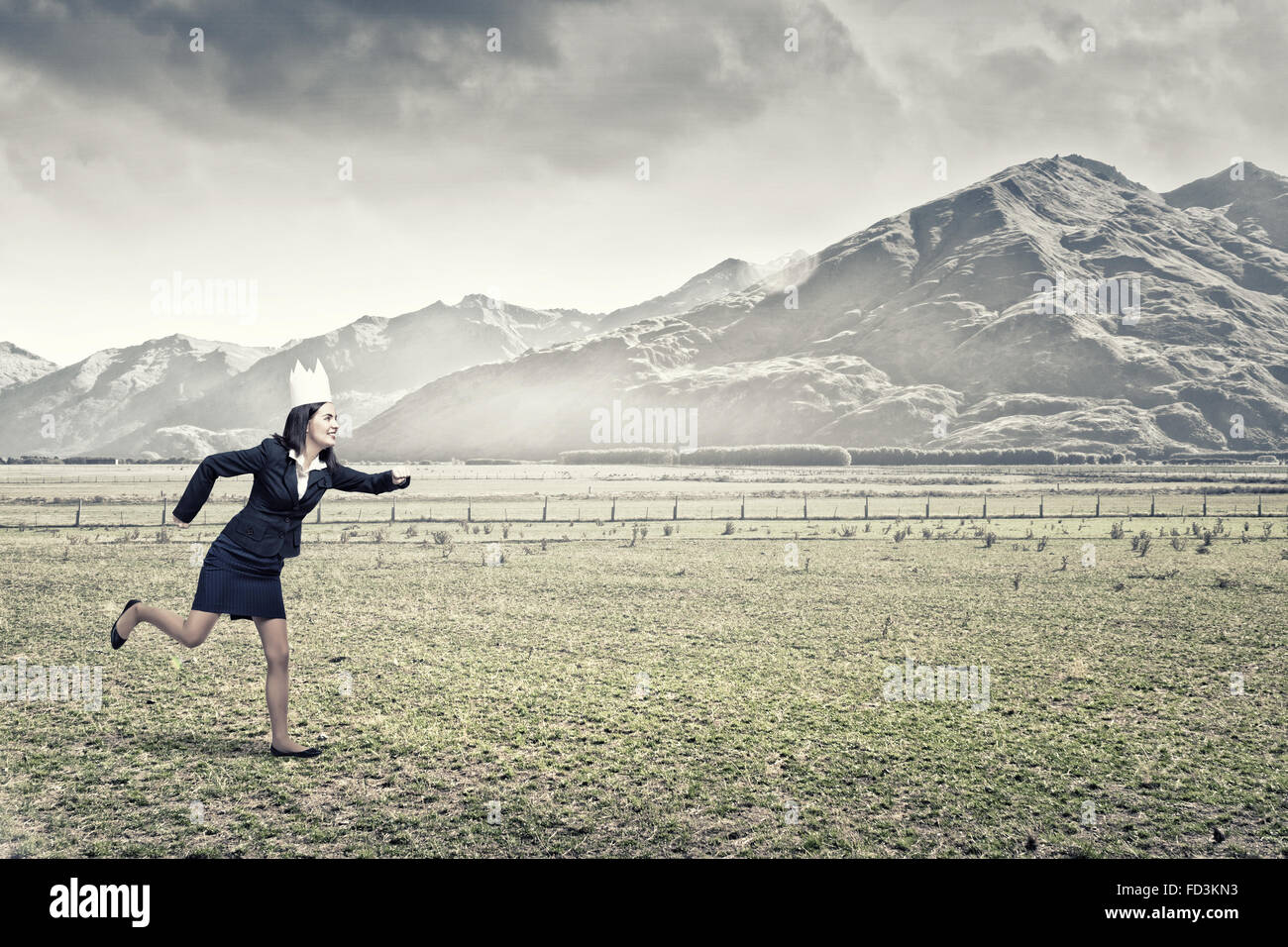 Young businesswoman in paper crown running in a hurry Stock Photo - Alamy