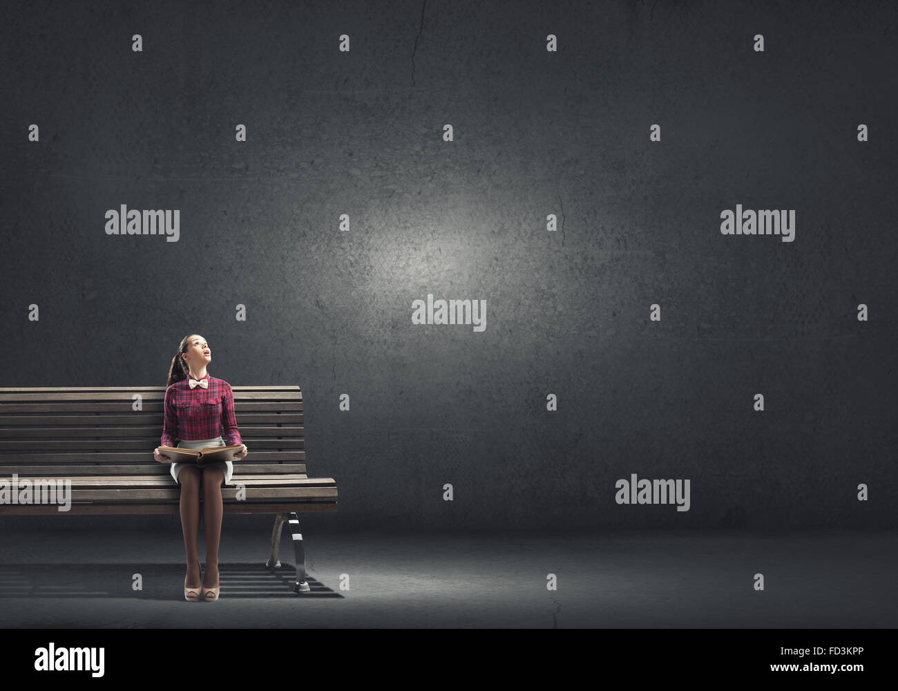 Young beautiful lady sitting on bench and reading book Stock Photo - Alamy
