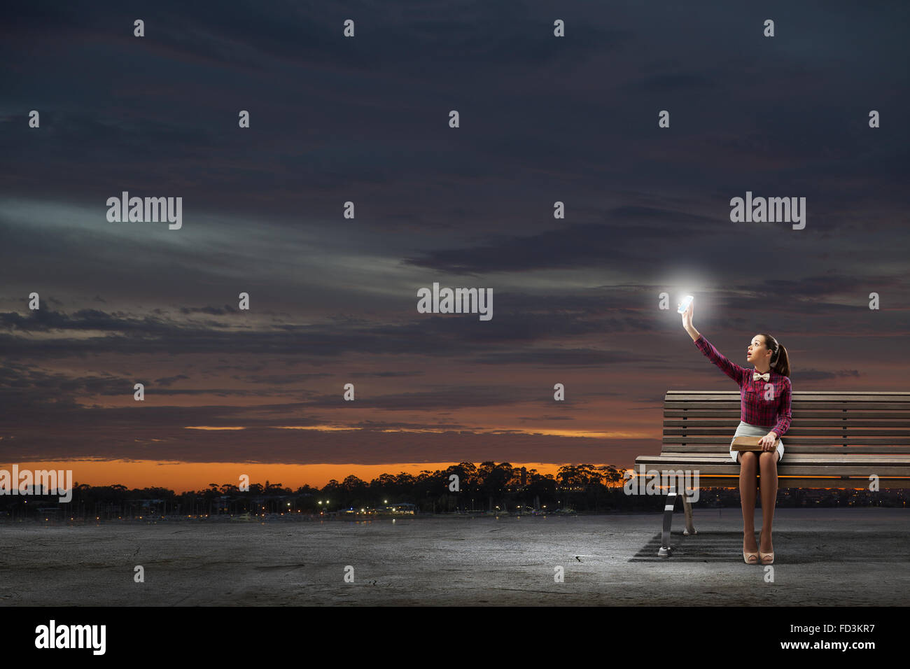 Young beautiful lady sitting on bench and reading book Stock Photo - Alamy