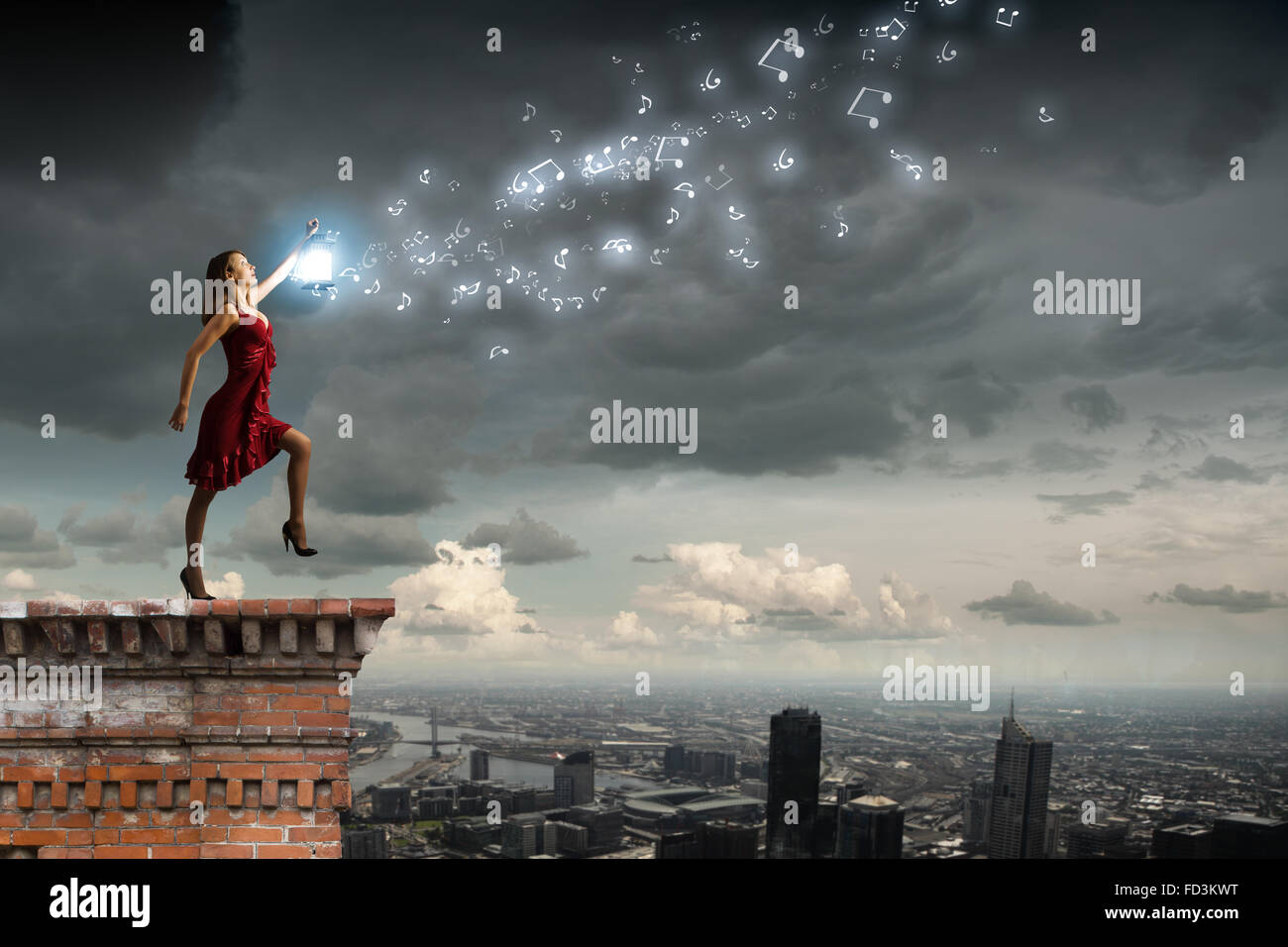 Young attractive woman in red dress with lantern walking in darkness ...