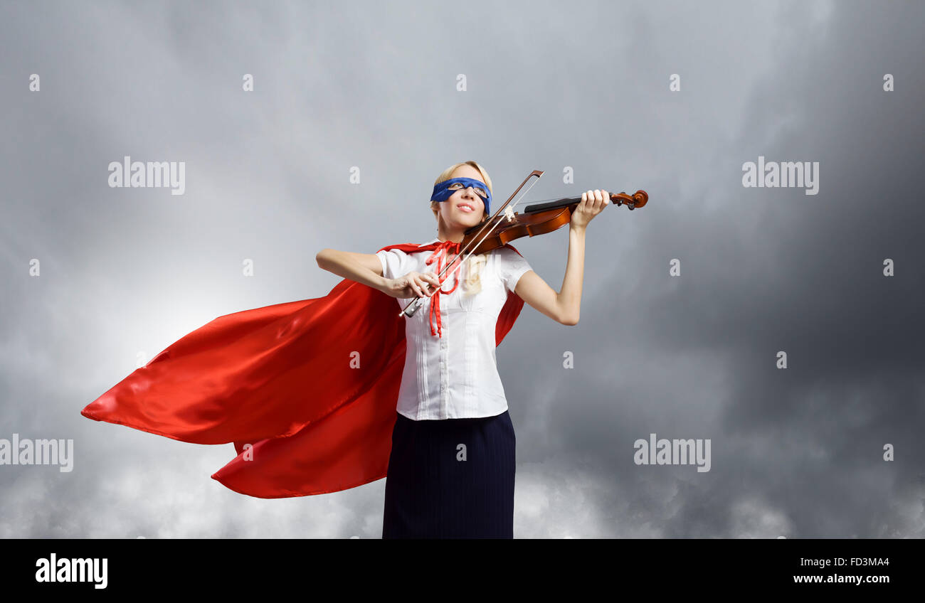 Young woman in super hero costume playing violin Stock Photo - Alamy