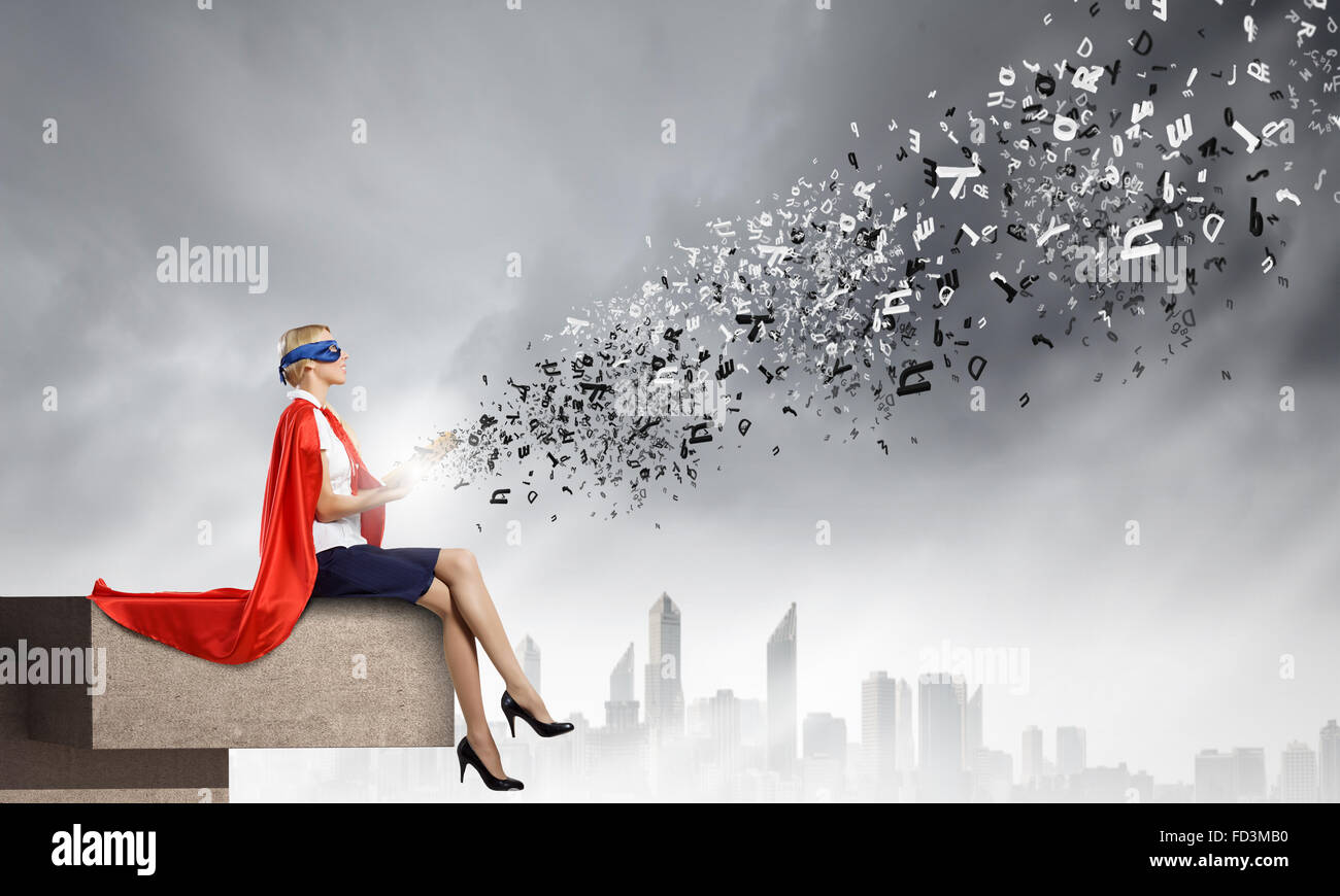 Young woman in super hero costume reading book hi-res stock photography ...
