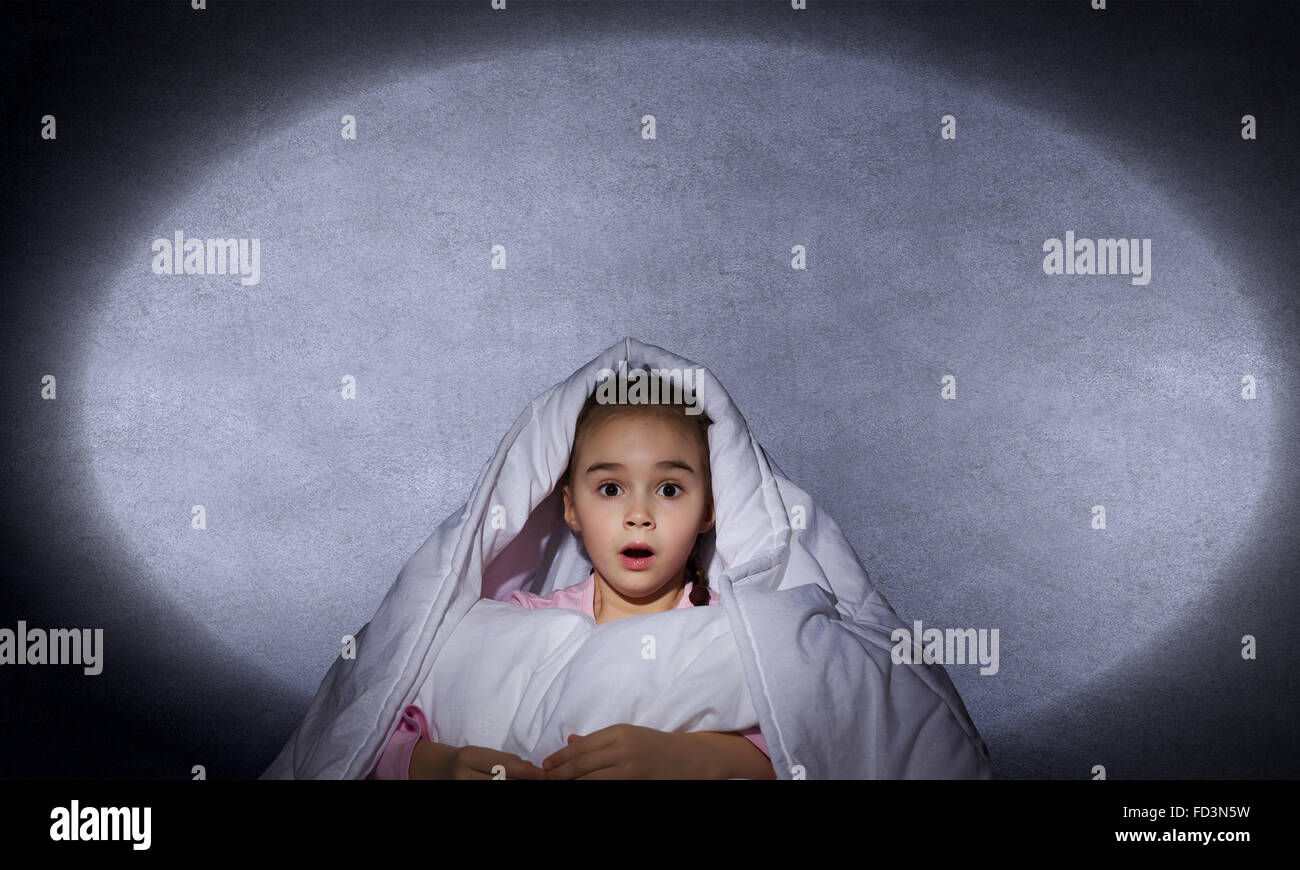 Cute scared girl sitting in bed under blanket Stock Photo - Alamy