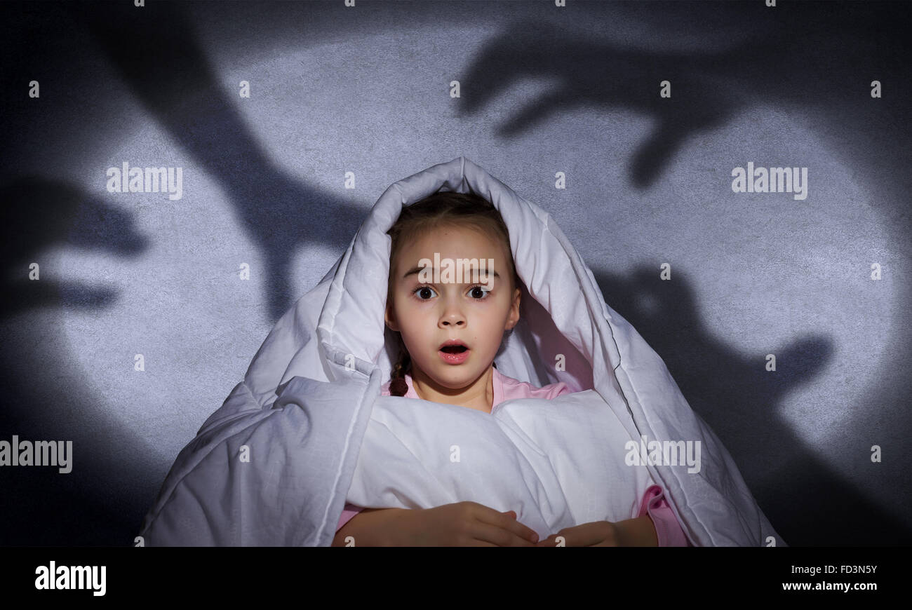 Cute scared girl sitting in bed under blanket Stock Photo - Alamy