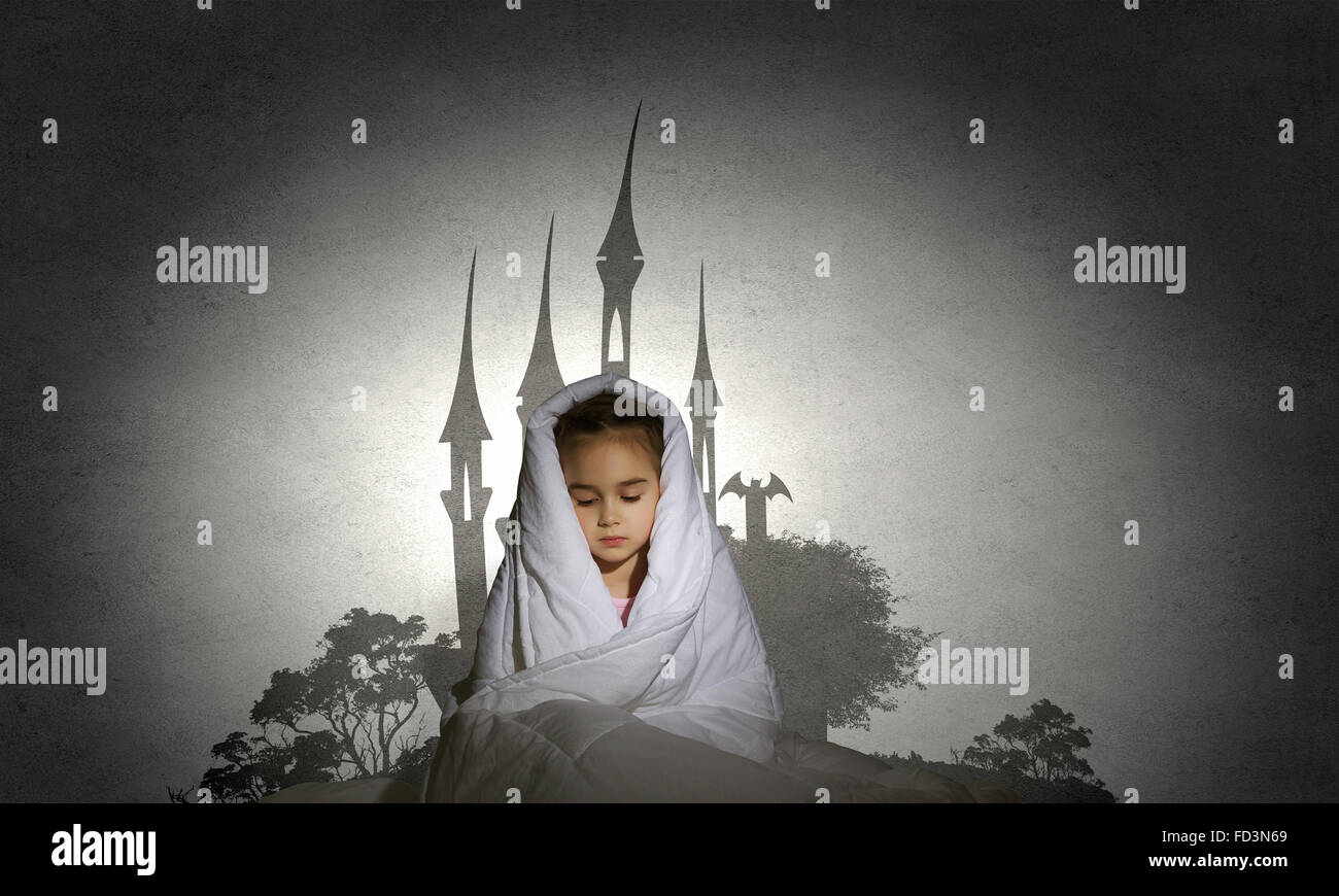 Cute scared girl sitting in bed under blanket Stock Photo - Alamy