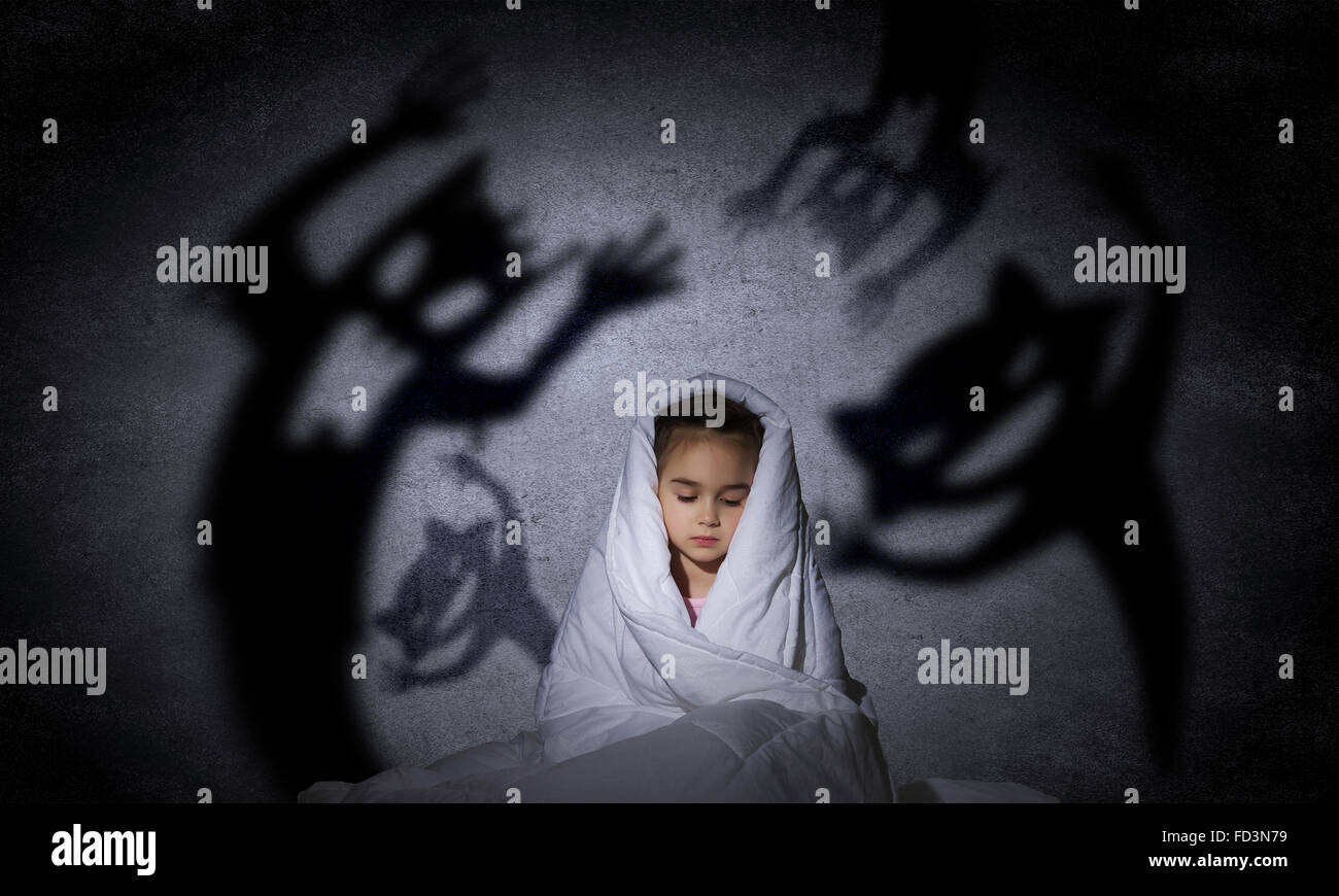 Cute scared girl sitting in bed under blanket Stock Photo - Alamy