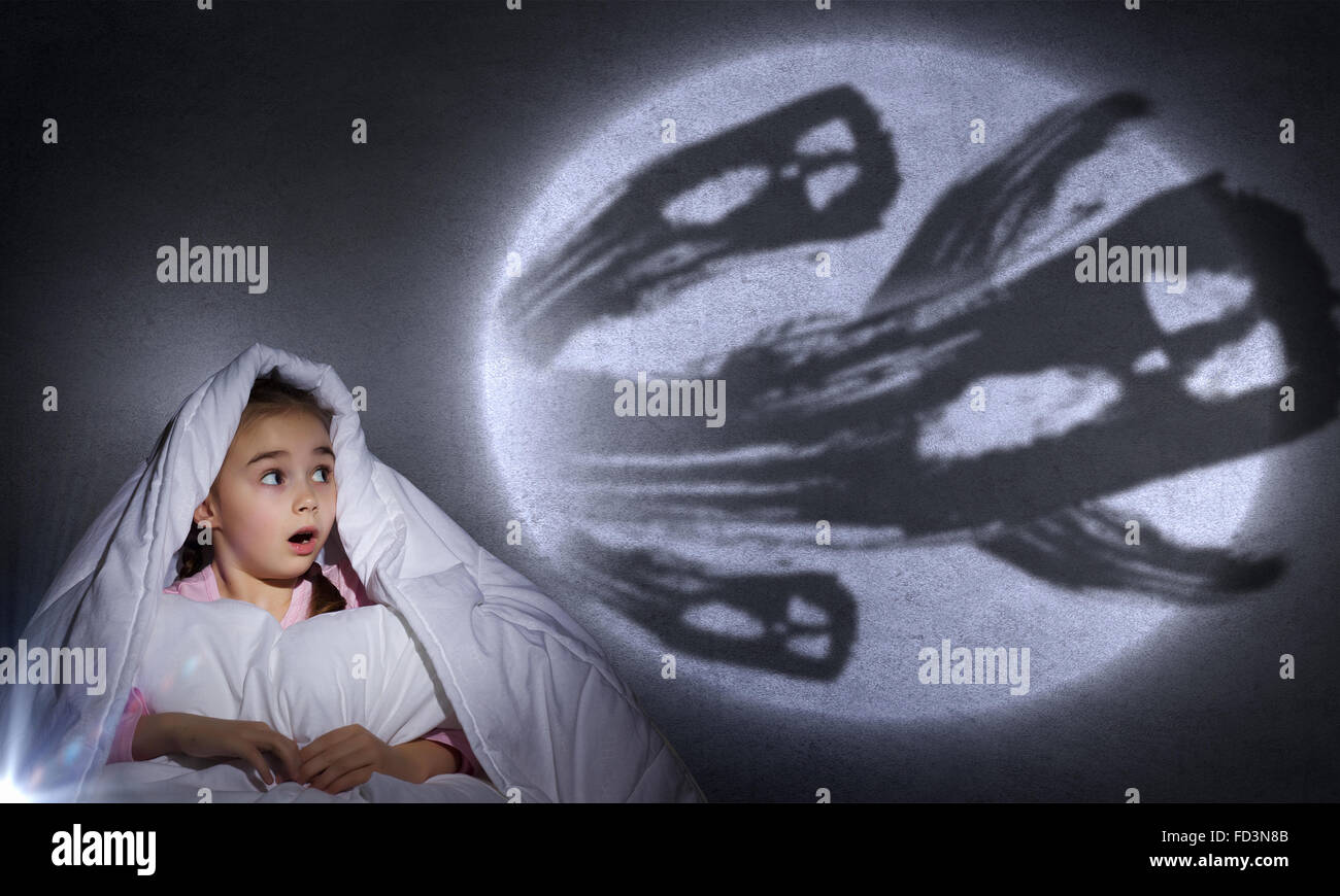 Cute scared girl sitting in bed under blanket Stock Photo - Alamy