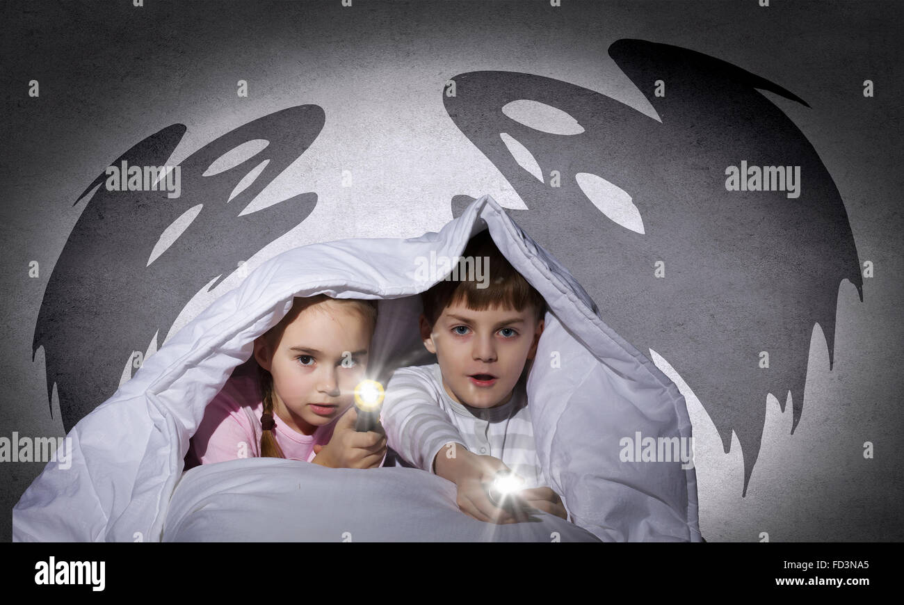 Children sitting in bed under blanket with flashlights Stock Photo - Alamy