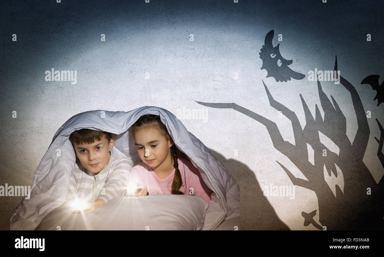 Children sitting in bed under blanket with flashlights Stock Photo - Alamy