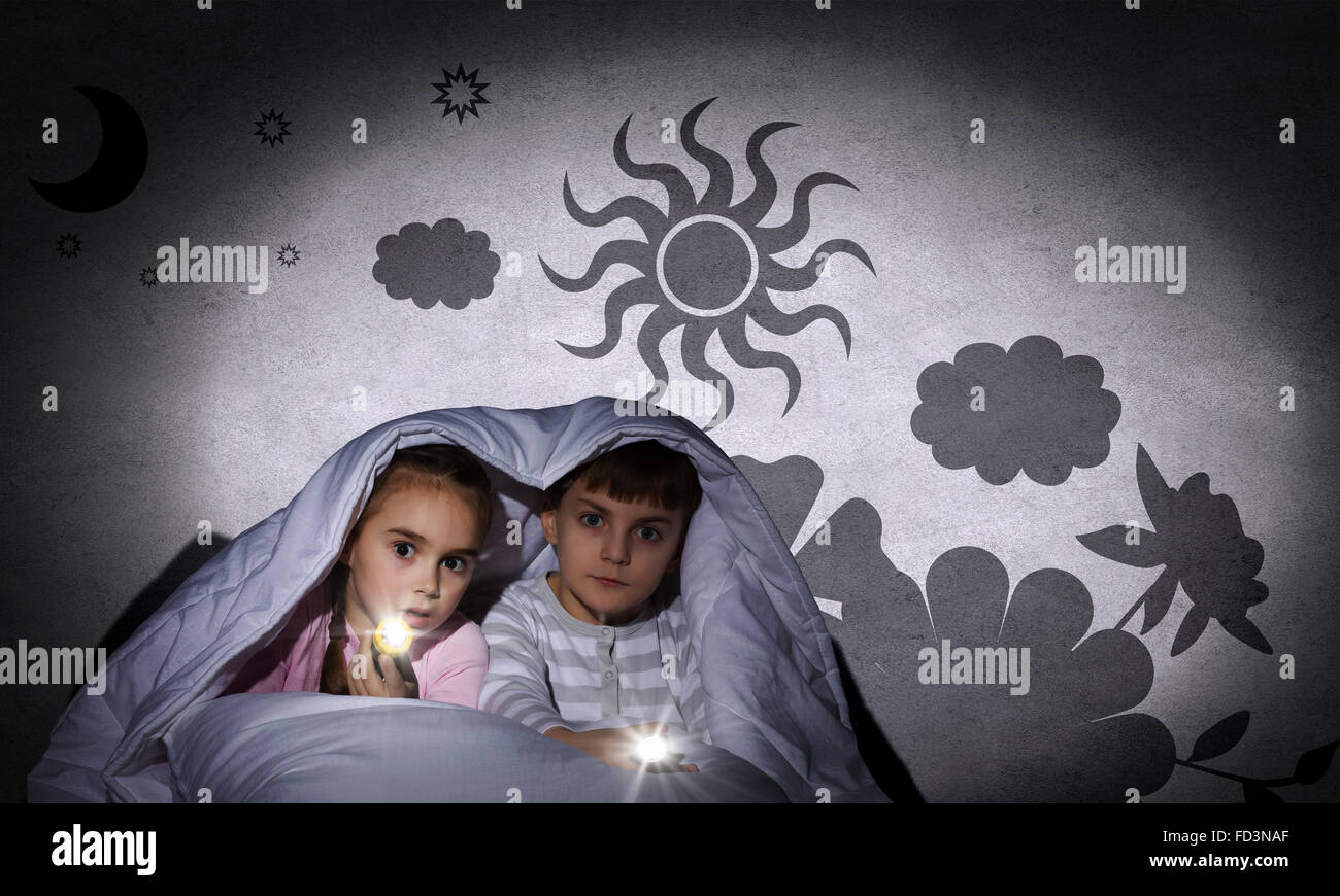 Children sitting in bed under blanket with flashlights Stock Photo - Alamy
