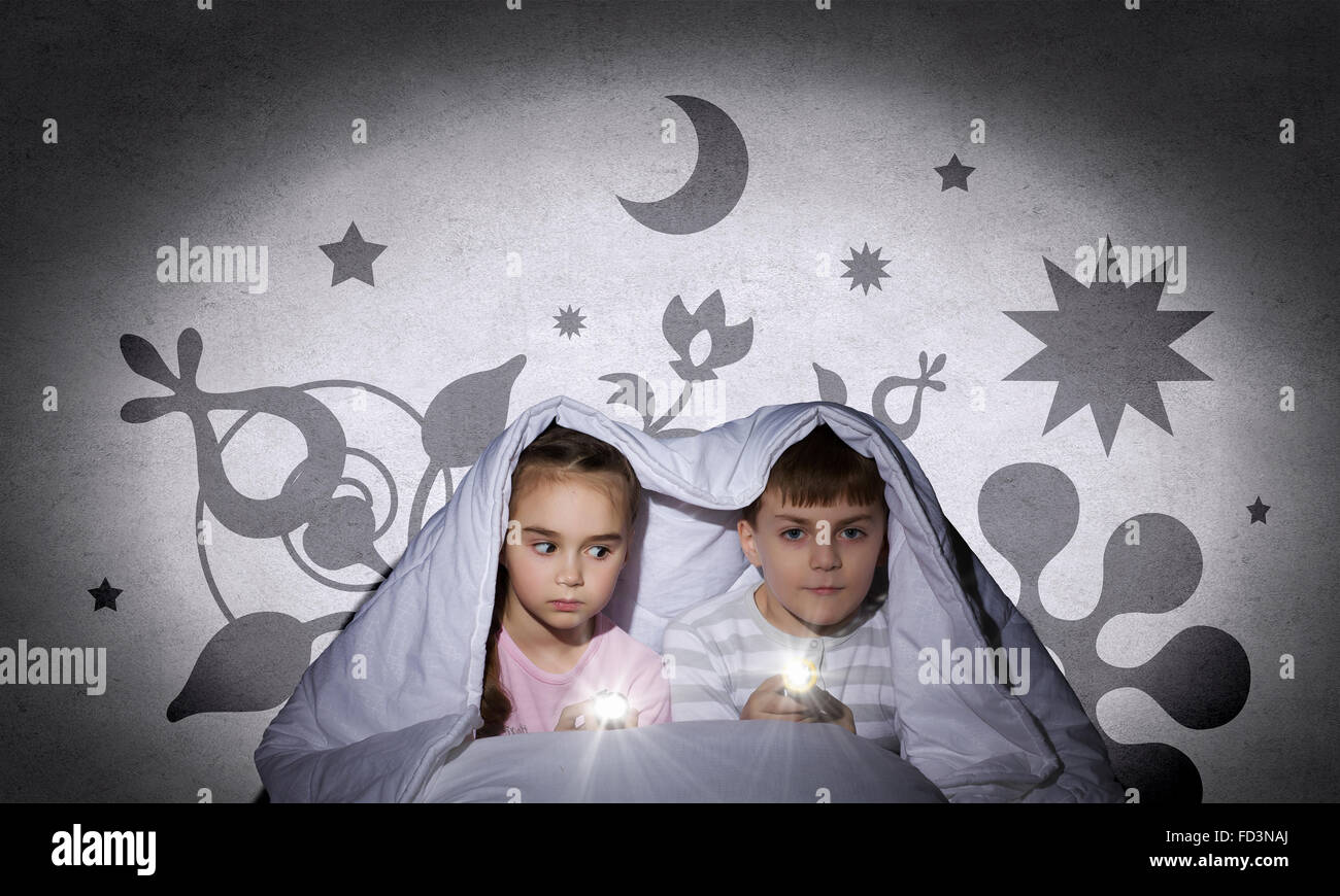 Children sitting in bed under blanket with flashlights Stock Photo - Alamy