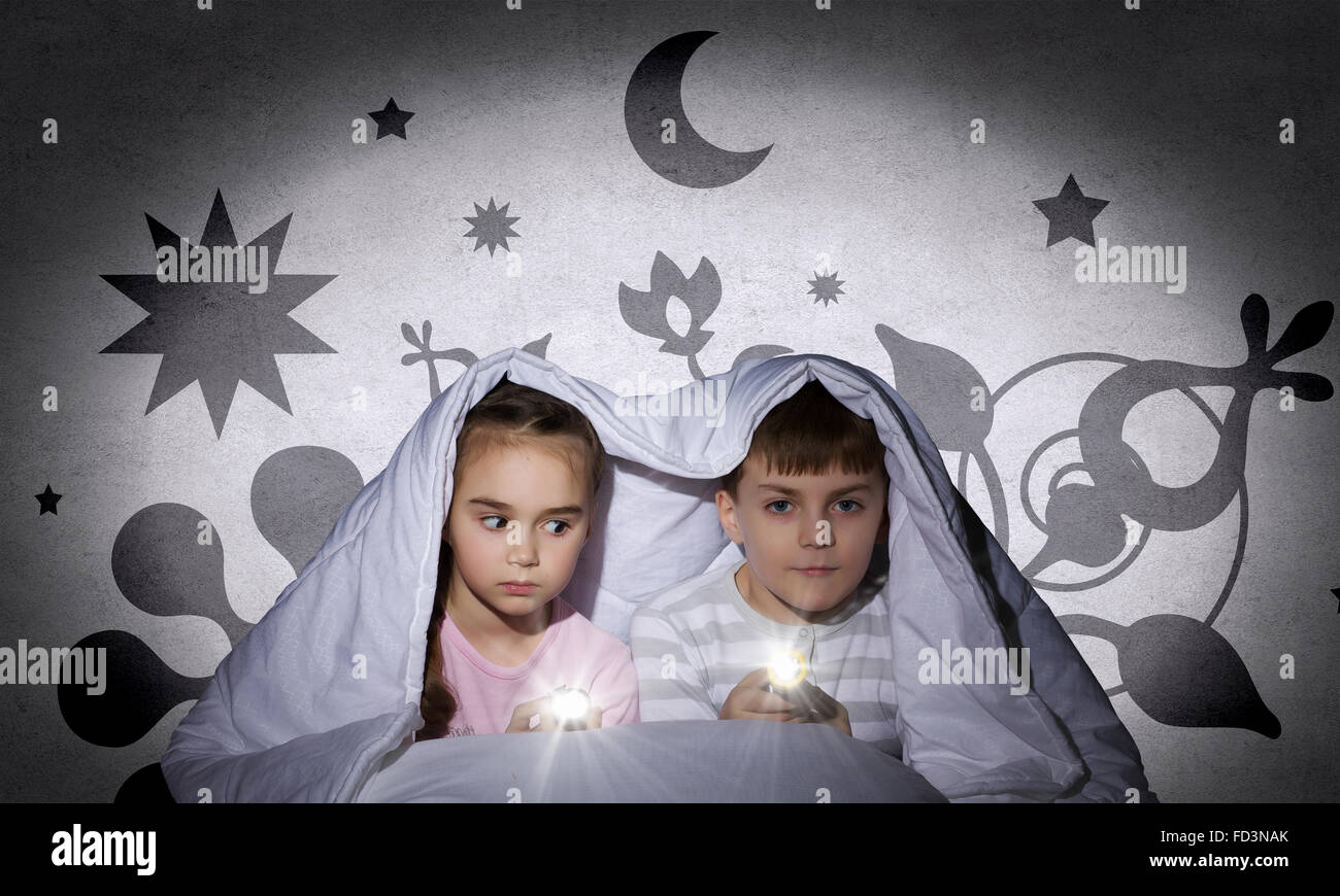 Children sitting in bed under blanket with flashlights Stock Photo - Alamy