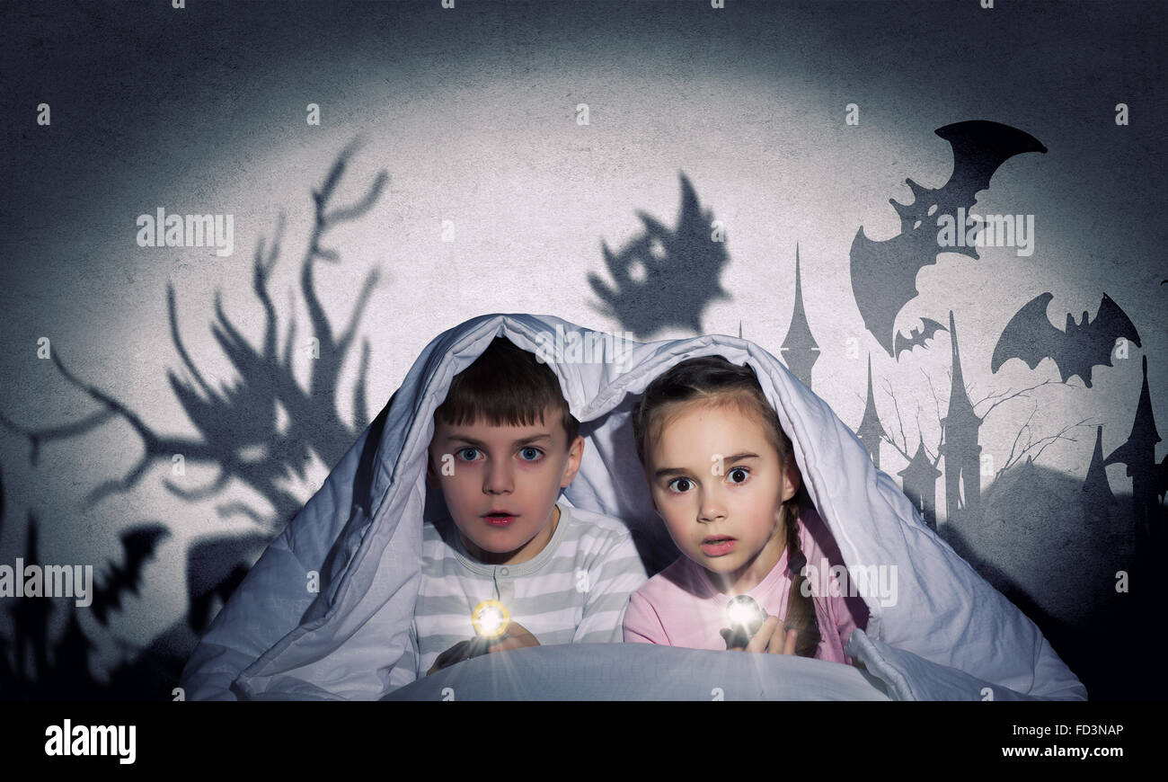 Children sitting in bed under blanket with flashlights Stock Photo - Alamy