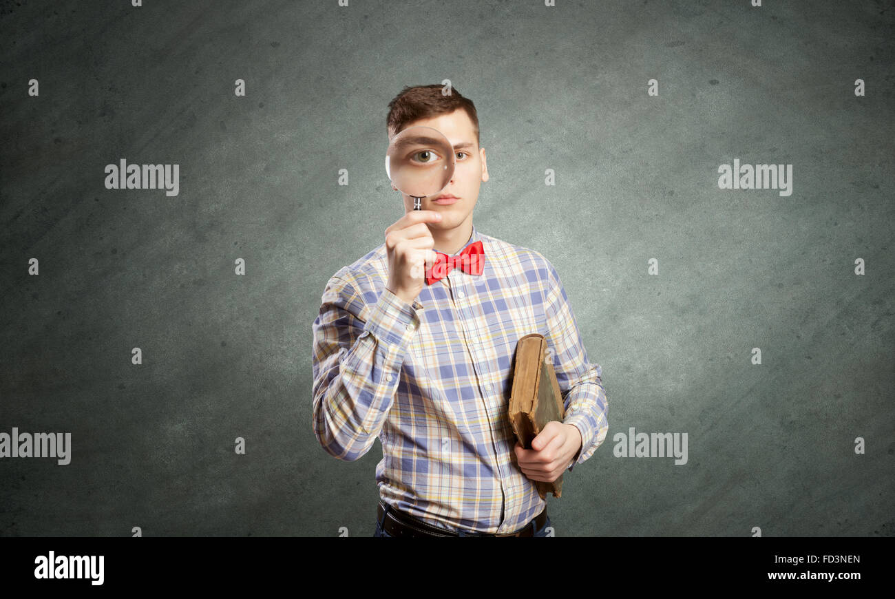 Young funny science man looking in magnifier Stock Photo - Alamy