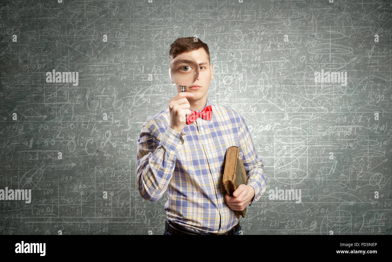 Young funny science man looking in magnifier Stock Photo - Alamy
