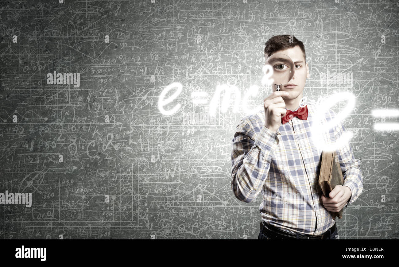 Young funny science man looking in magnifier Stock Photo - Alamy