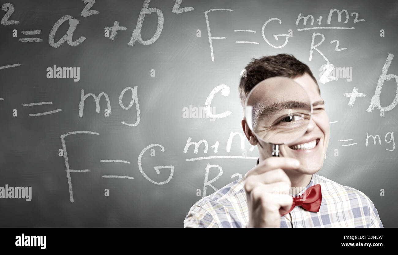 Young funny science man looking in magnifier Stock Photo - Alamy