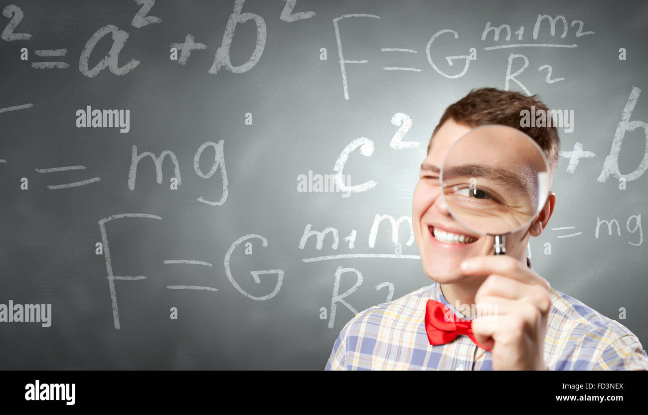 Young funny science man looking in magnifier Stock Photo - Alamy