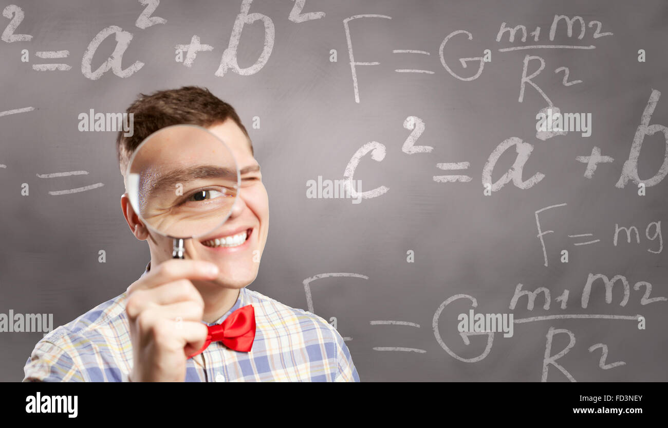 Young funny science man looking in magnifier Stock Photo - Alamy