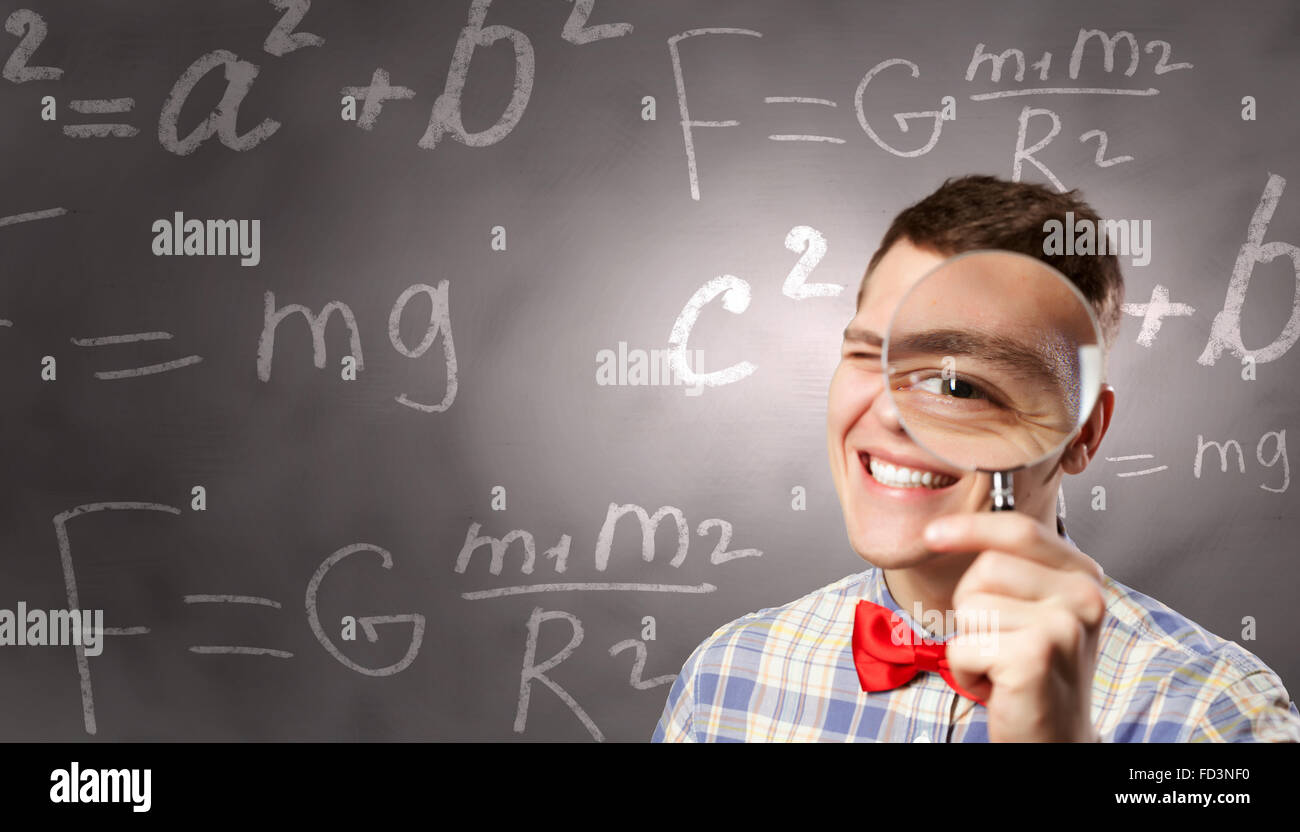 Young funny science man looking in magnifier Stock Photo - Alamy