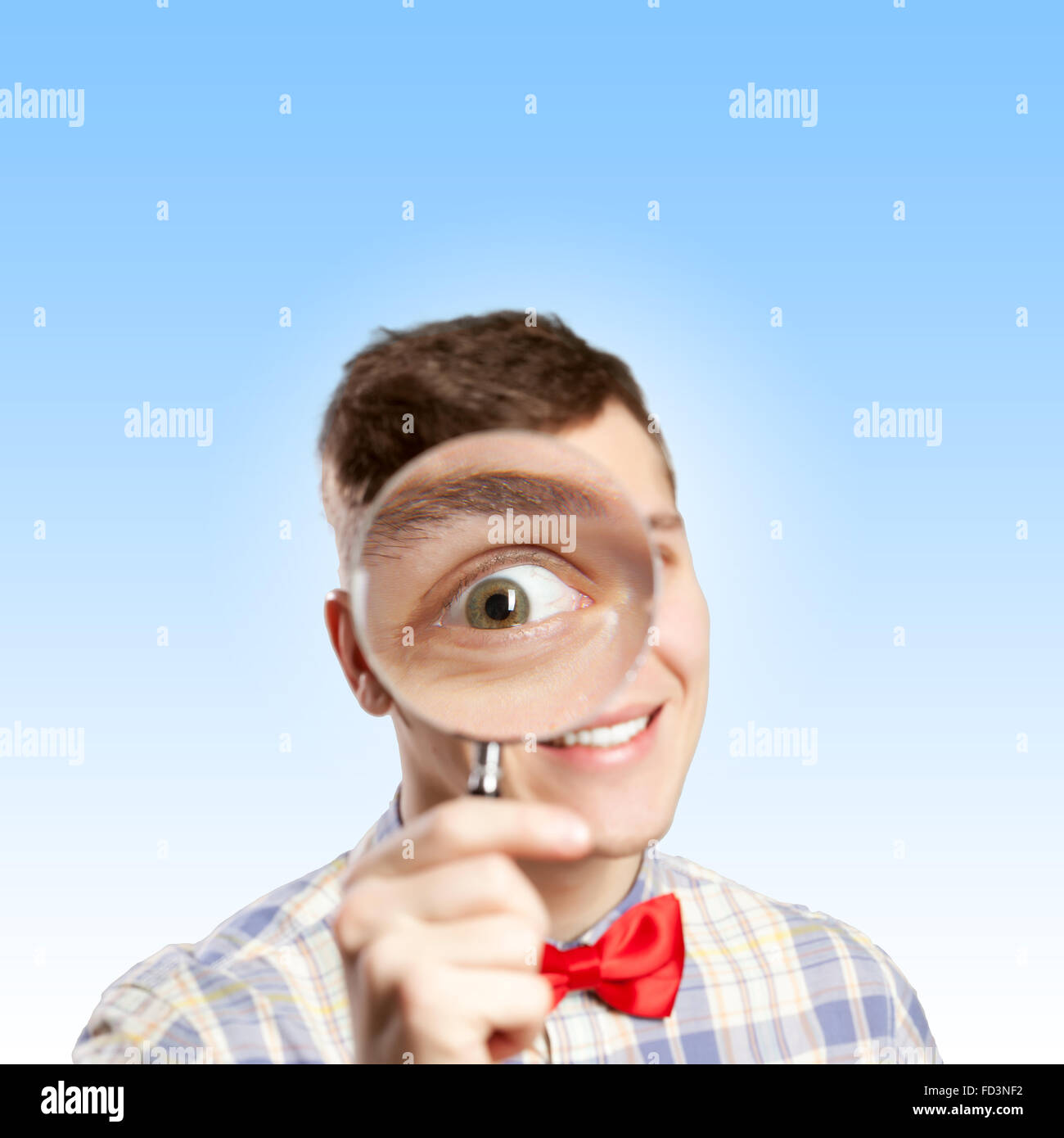 Young funny science man looking in magnifier Stock Photo - Alamy