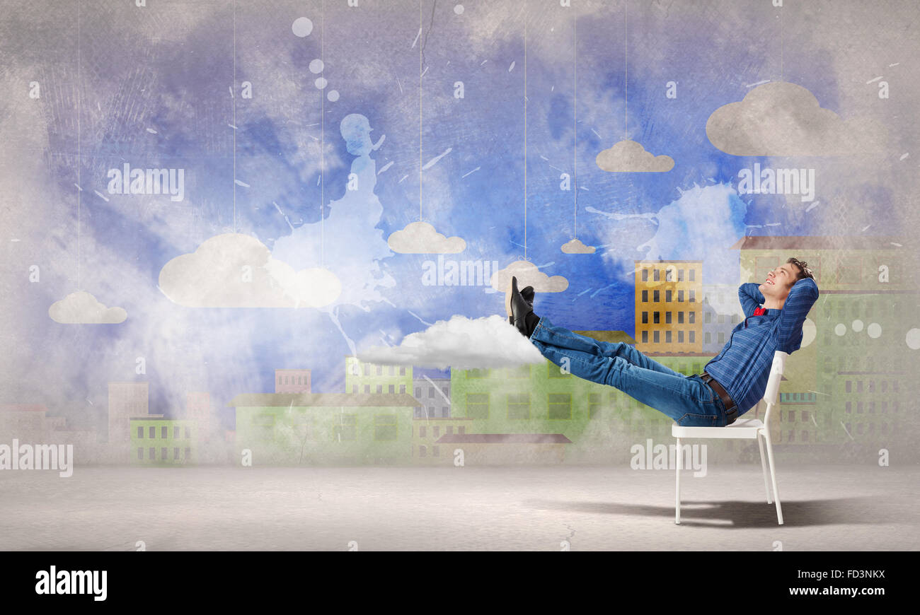 Young man sitting in chair with legs up and relaxing Stock Photo - Alamy