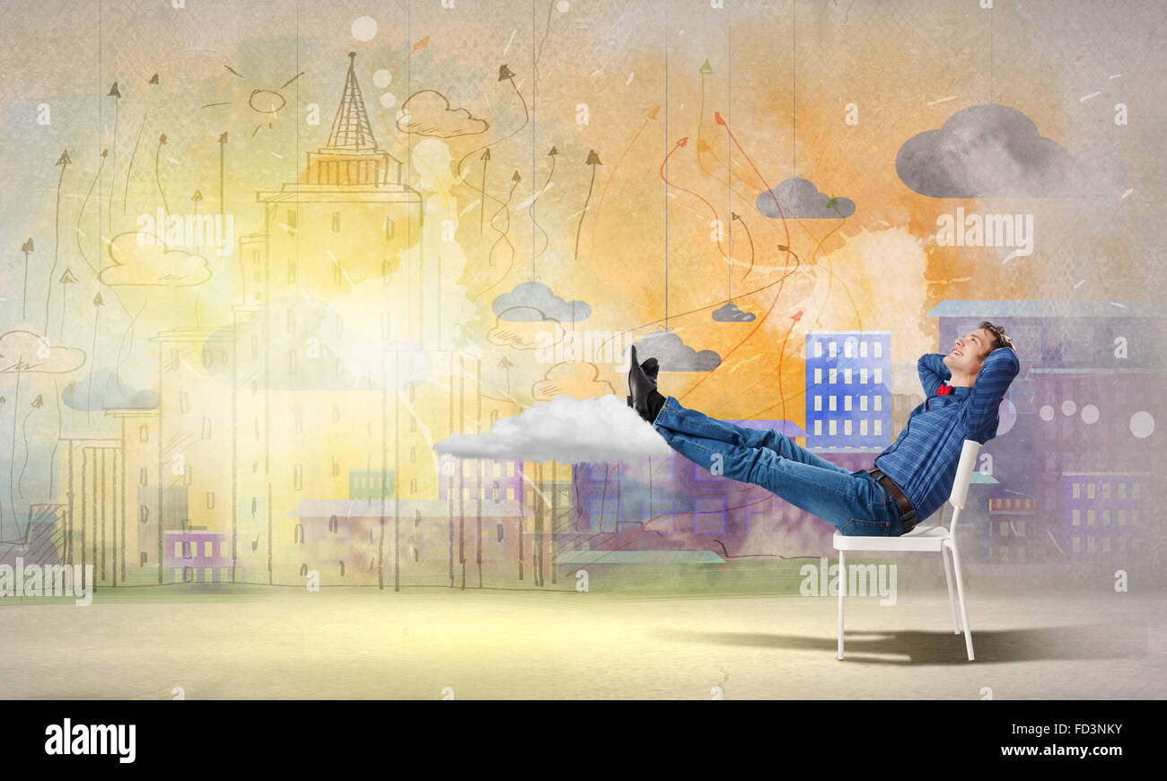 Young man sitting in chair with legs up and relaxing Stock Photo - Alamy