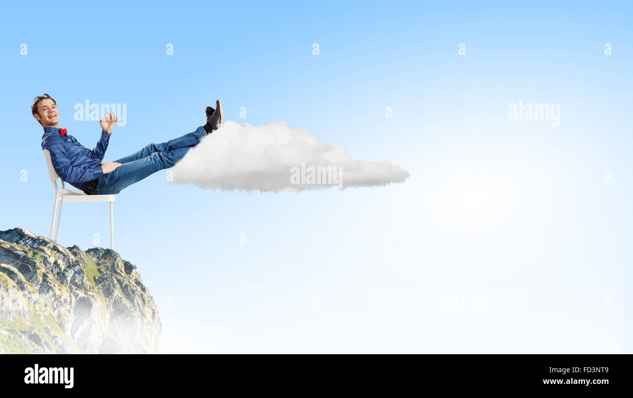 Young man sitting in chair with legs up and relaxing Stock Photo - Alamy