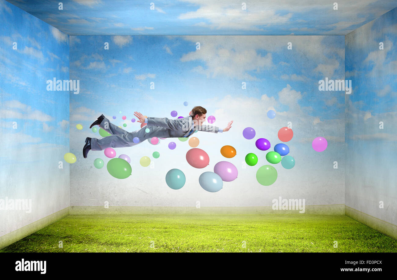 Young man flying in sky among flying around papers Stock Photo - Alamy