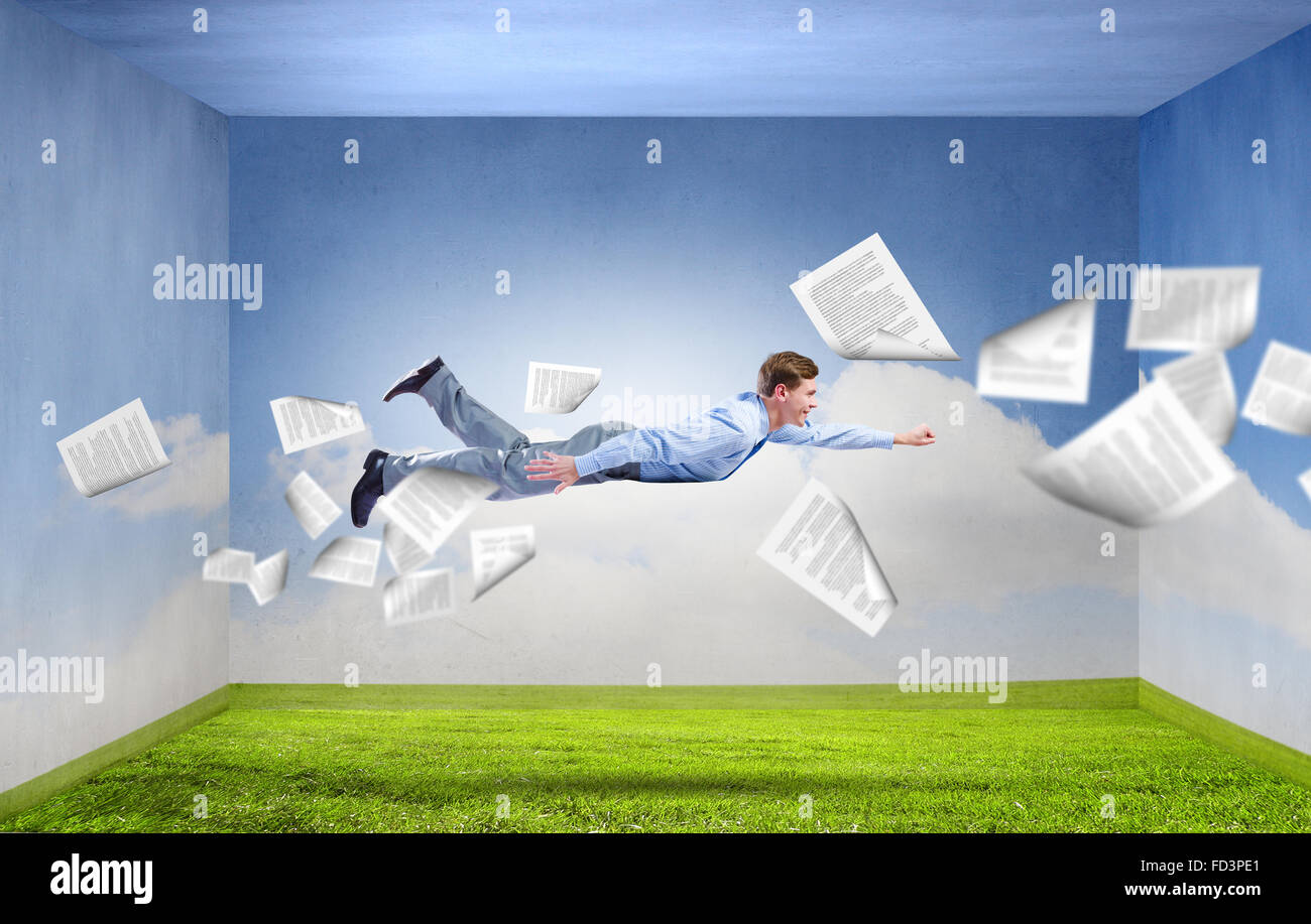 Young man flying in sky among flying around papers Stock Photo - Alamy